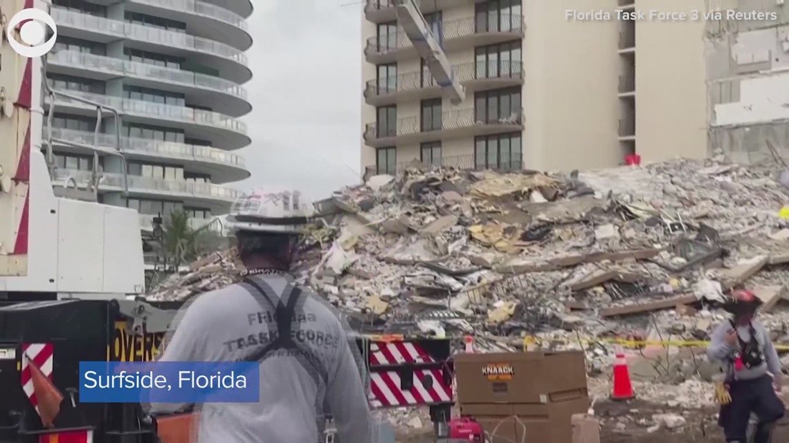 Crews work to remove large pieces of concrete at the site of the ...