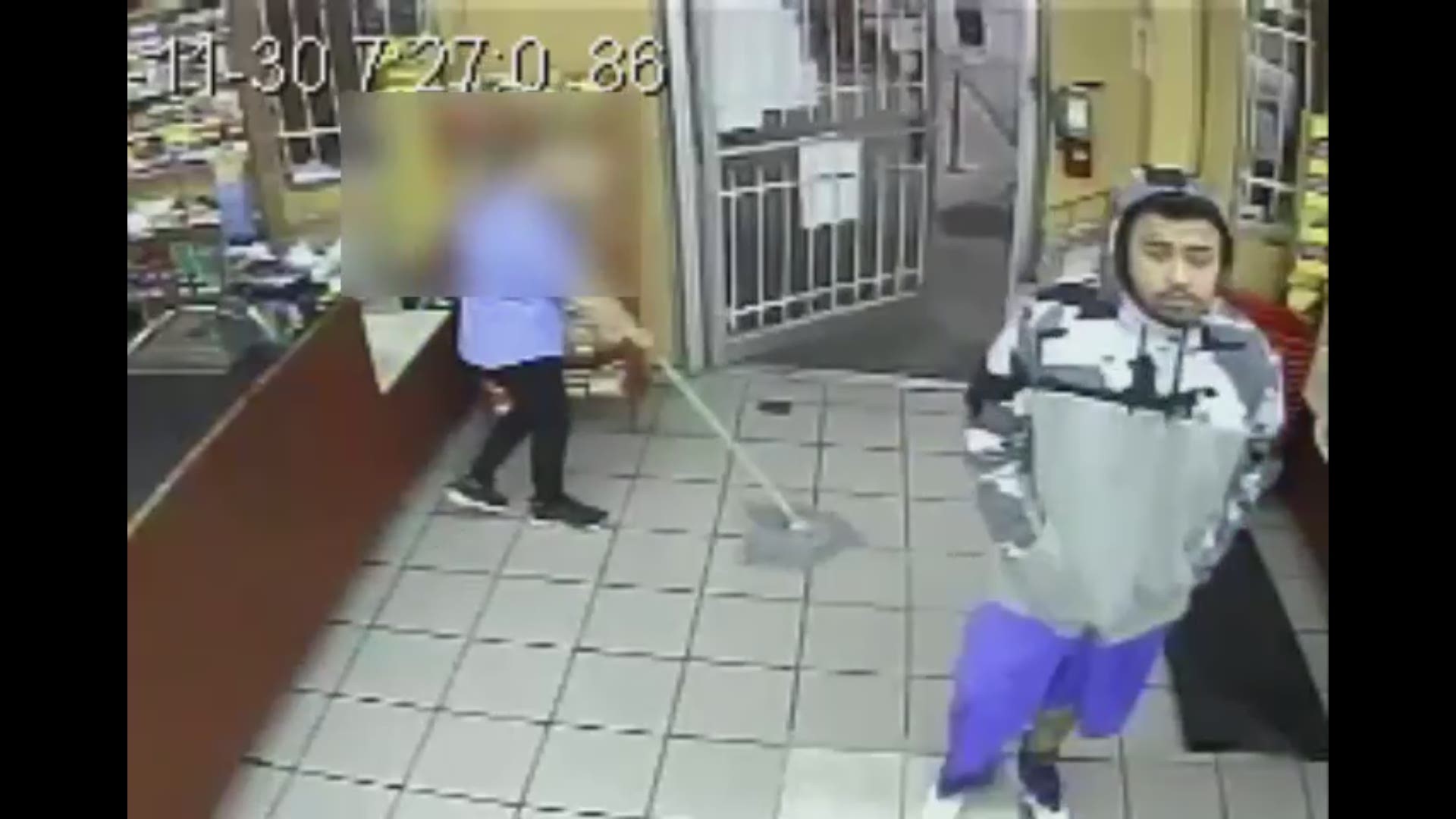 Watch: Suspect talks on cell phone during meat market robbery | khou.com